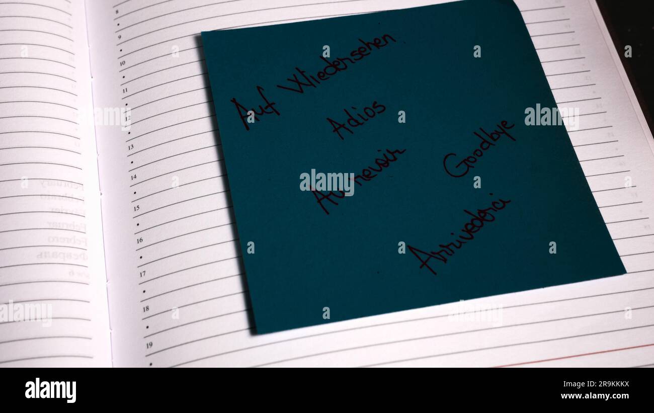 Writing Bye in different languages on memo post reminder. Text on ...