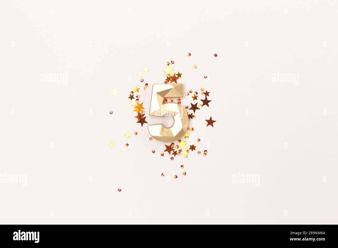 Golden number five and stars confetti on a gray background. Festive ...