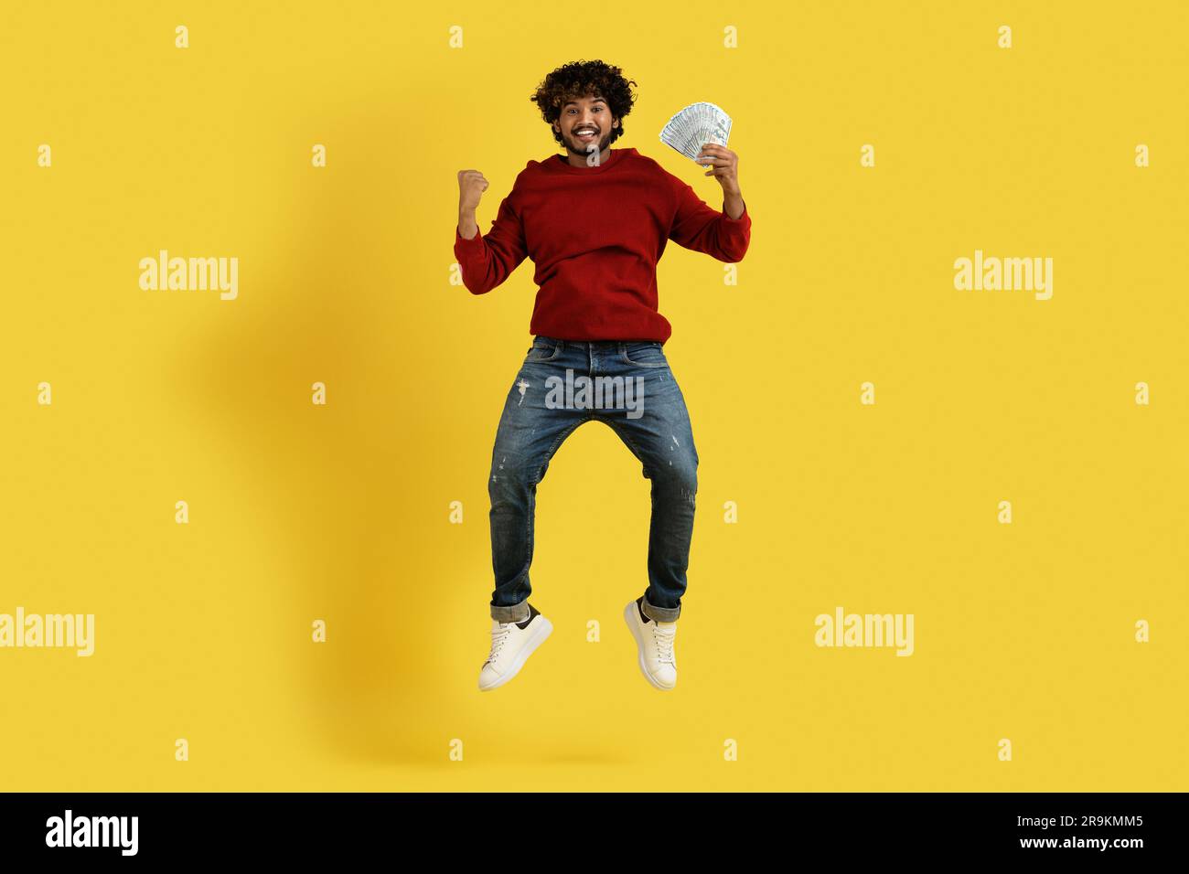 Happy rich young indian guy holding money cash, jumping up Stock Photo ...