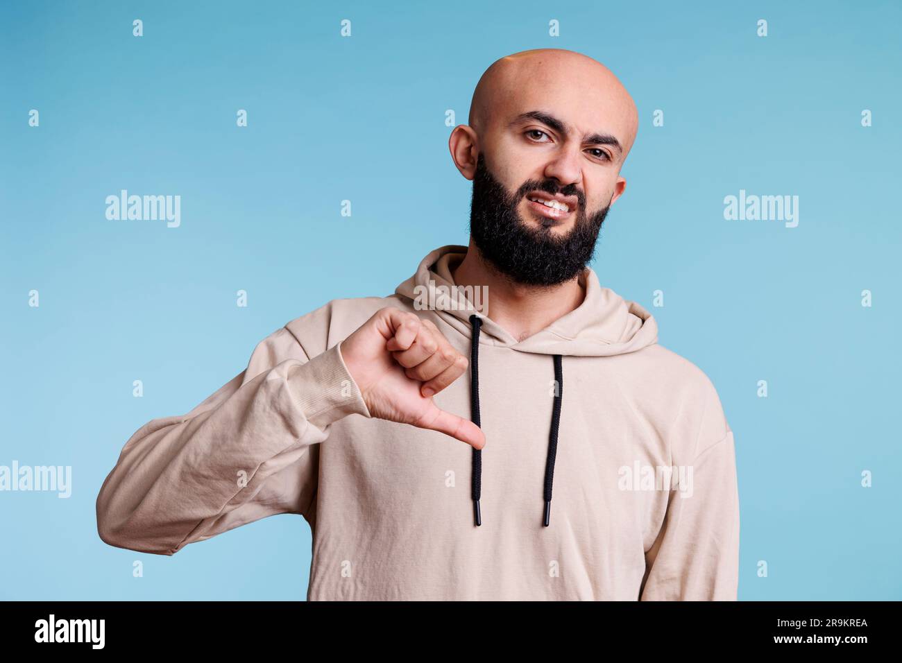 Arab man showing dislike with thumb down, expressing negative emotion ...