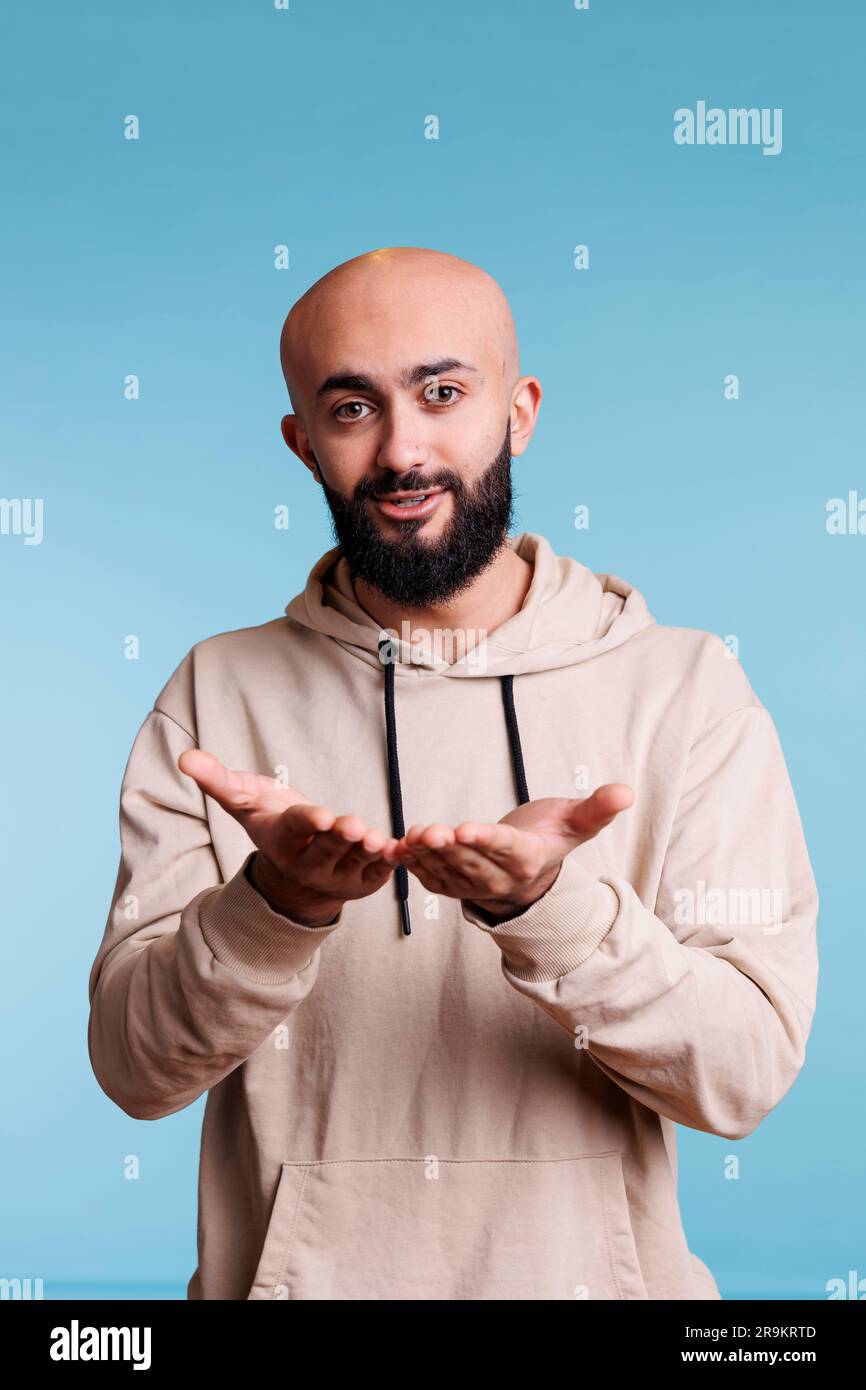 Charming arab man flirting and sending air kiss while looking at camera ...