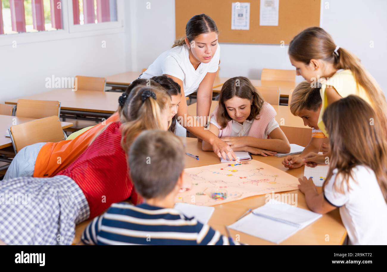 Schoolkids with teacher playing educational tabletop game in classroom ... Schoolkids with teacher playing educational tabletop game in classroom ...