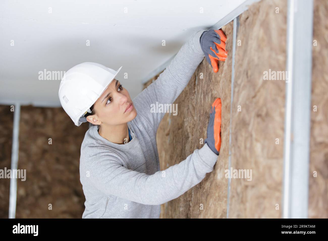female worker at a indoors wall insulation Stock Photo - Alamy