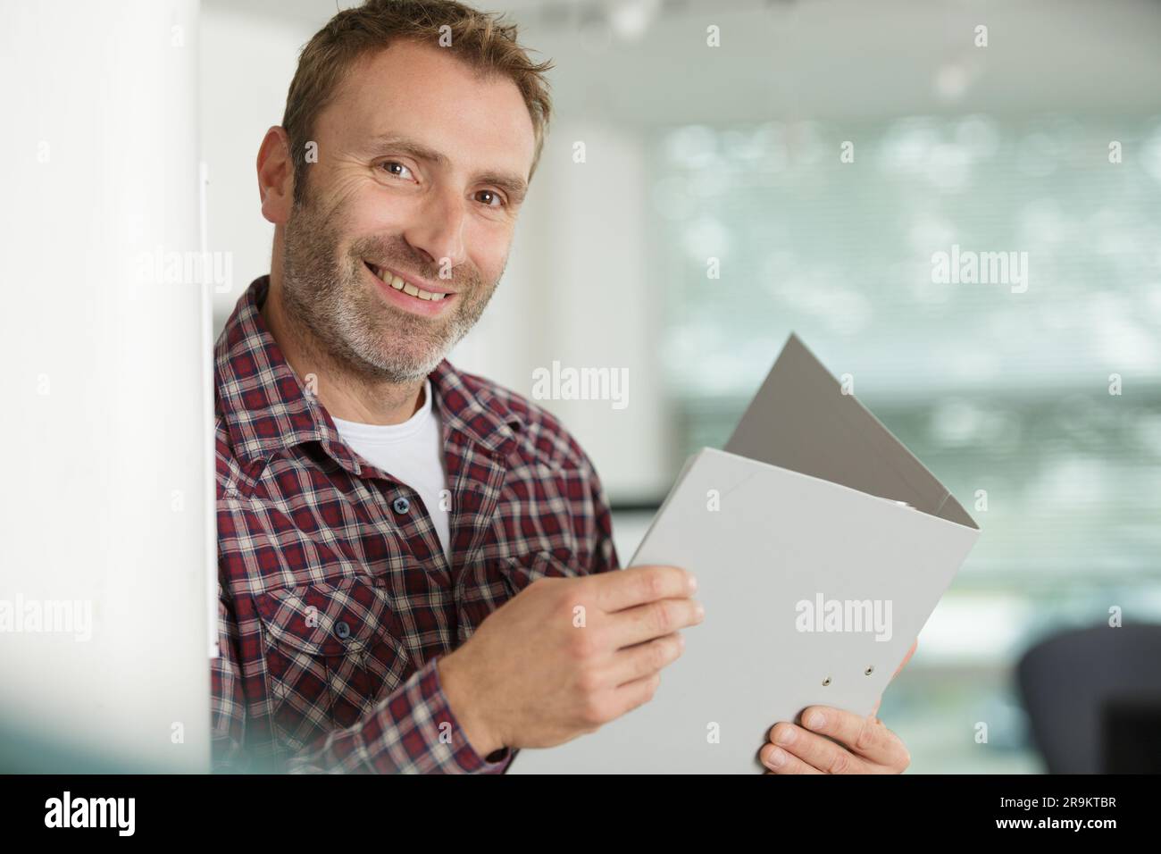 picture of man smiling holding an open folder Stock Photo - Alamy
