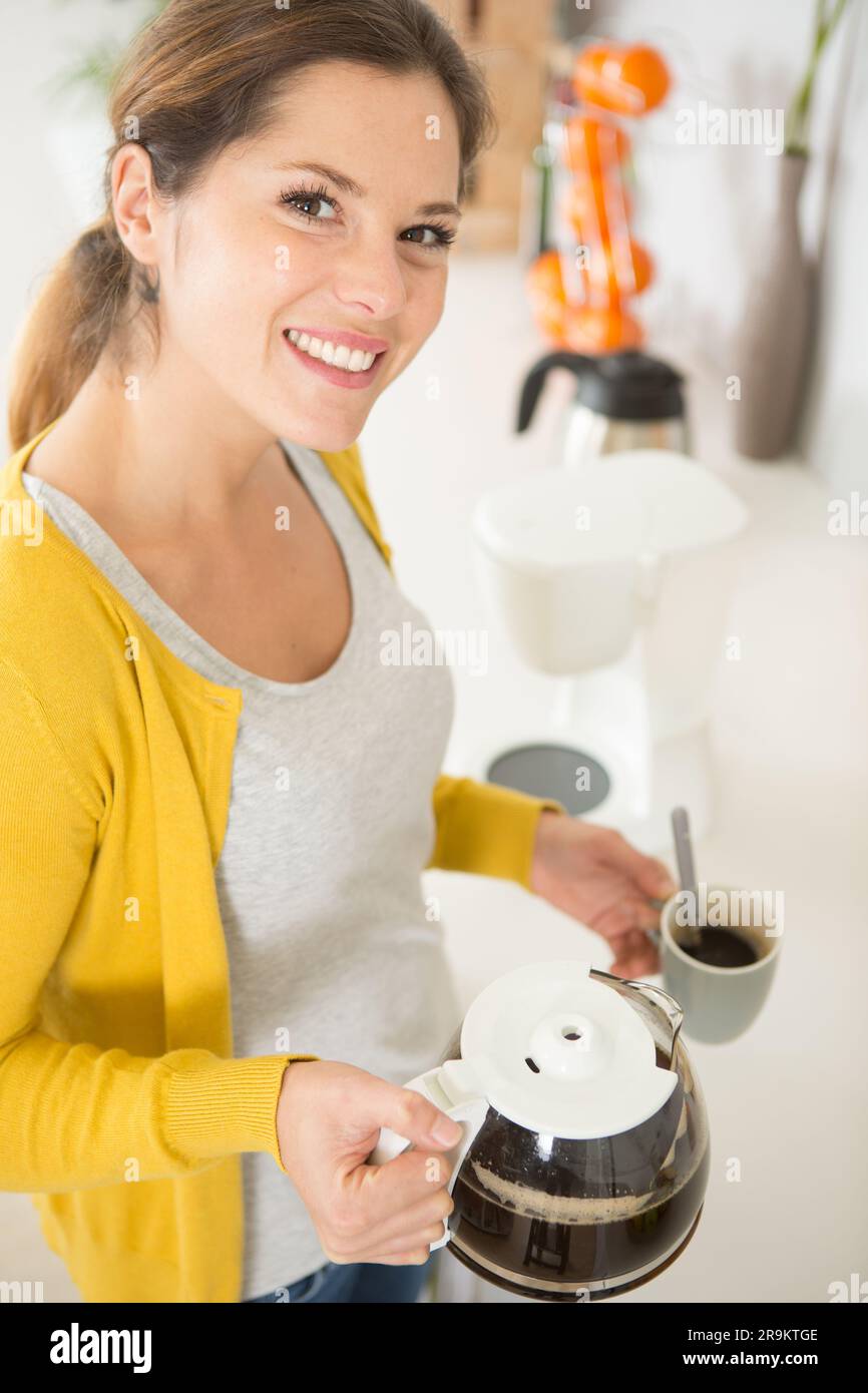 pretty woman holding jug of coffee in the home Stock Photo - Alamy