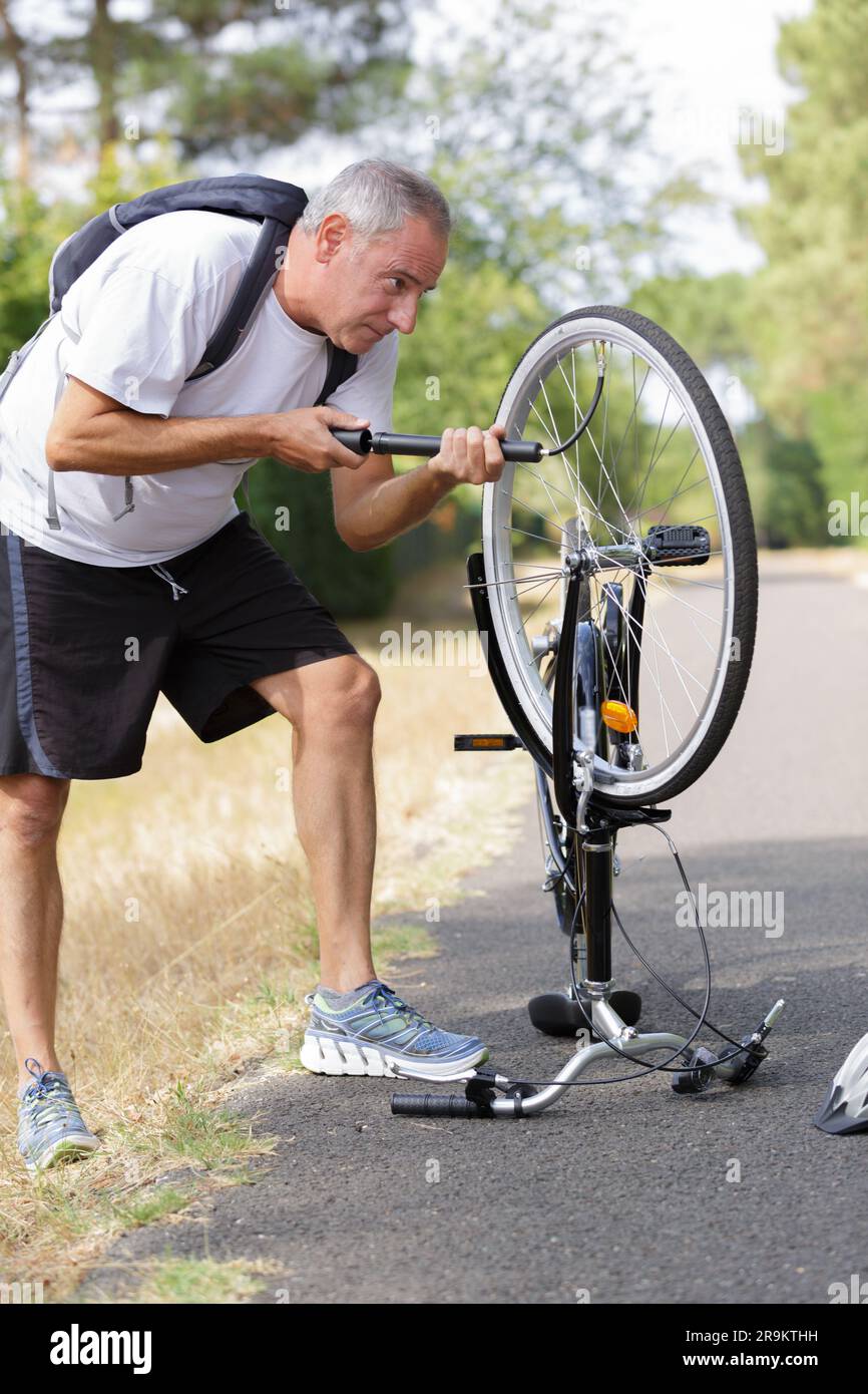 man pumping bicycle wheel with air pump Stock Photo - Alamy