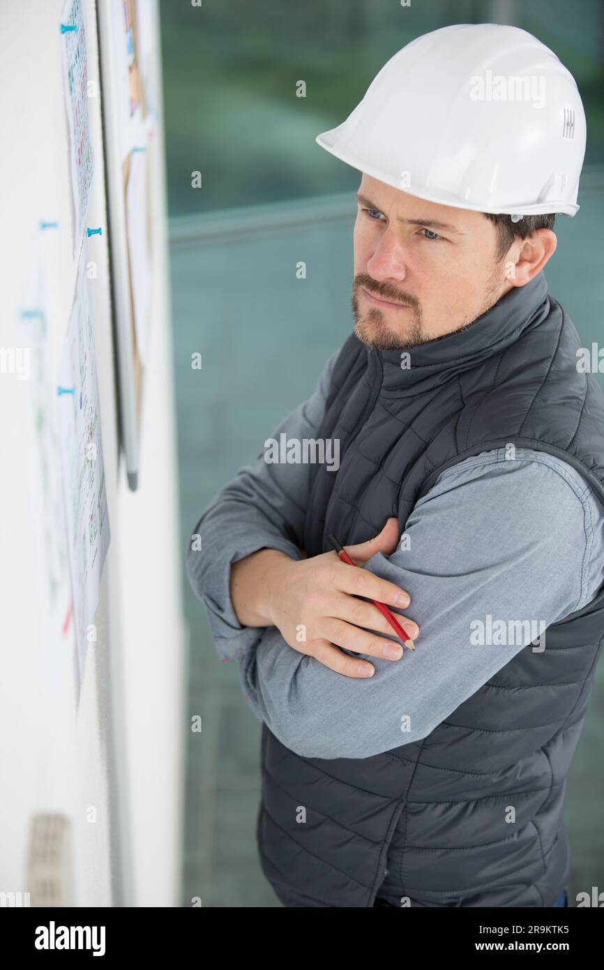 workman reading notices on a board Stock Photo - Alamy