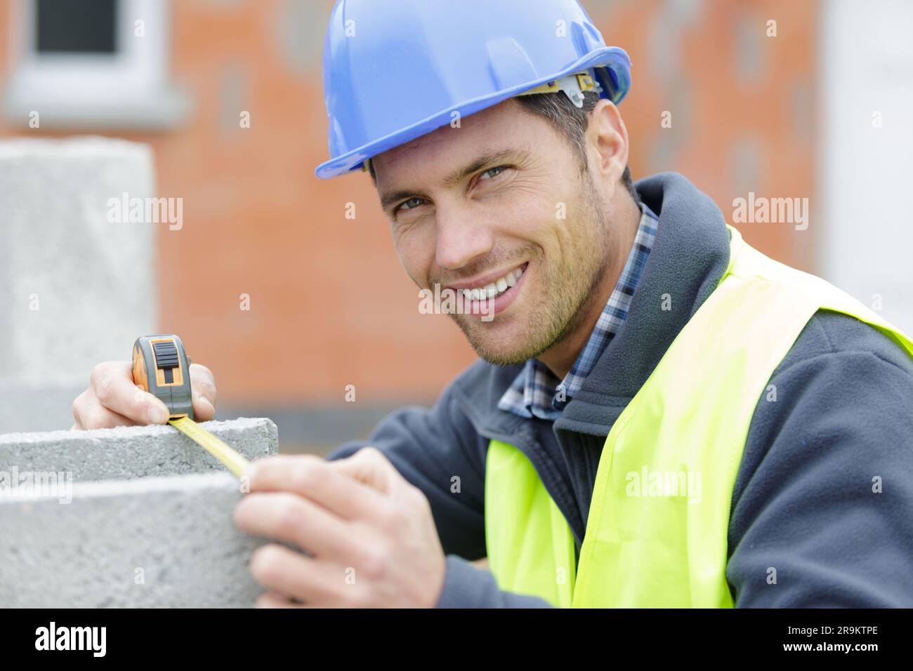 happy male repair work measuring a wall Stock Photo - Alamy
