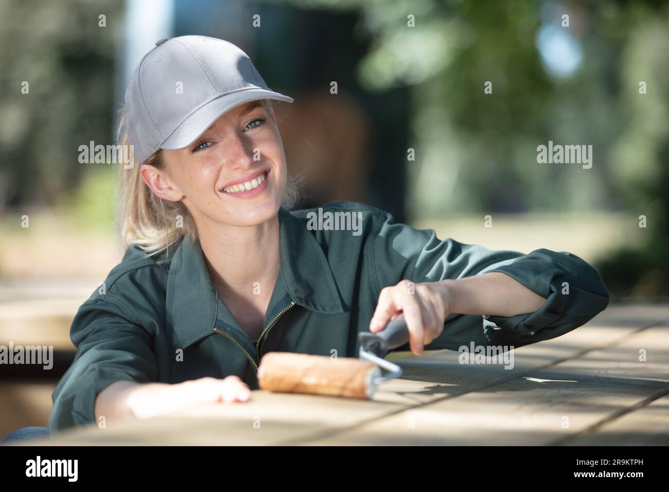 lady applying wood preserver with a paint roller Stock Photo - Alamy