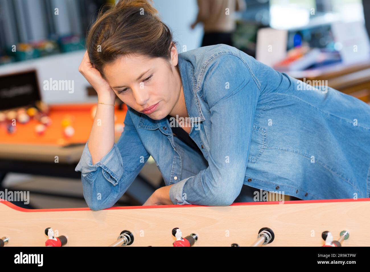 bored woman alone while husband is playing table football Stock Photo ...