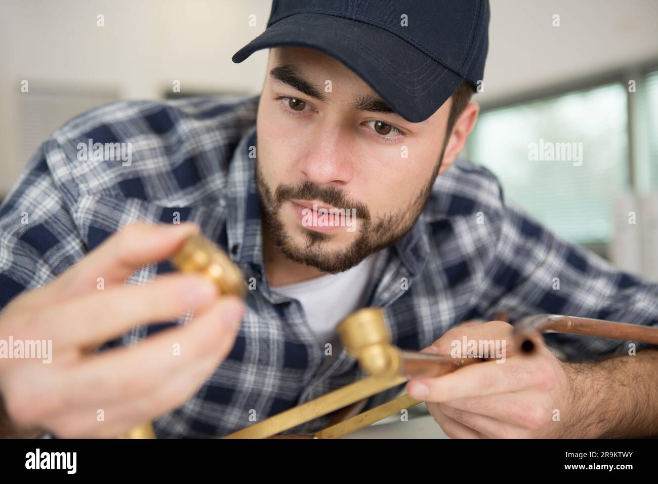 male worker finding correct copper pipe fittings Stock Photo - Alamy