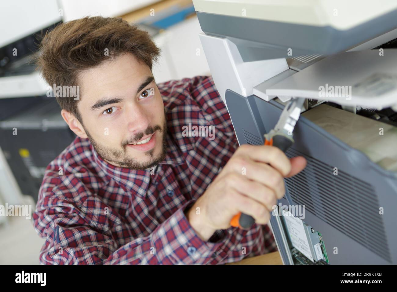 happy young man fixing a printer Stock Photo - Alamy