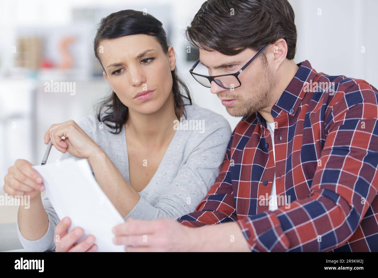 serious couple looking at paperwork together Stock Photo - Alamy