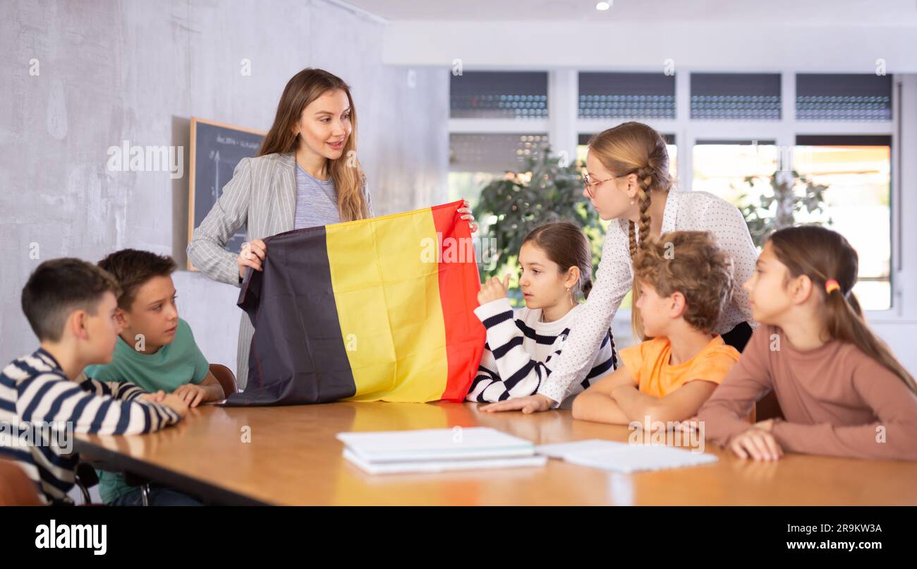 Students sitting in class and listening carefully to female teacher ...