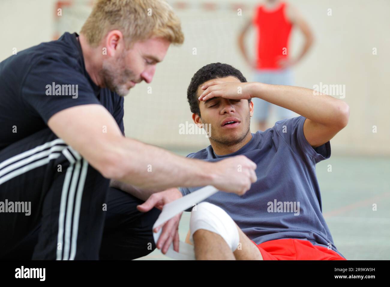 man applying compression bandage to players ankle injury Stock Photo ...
