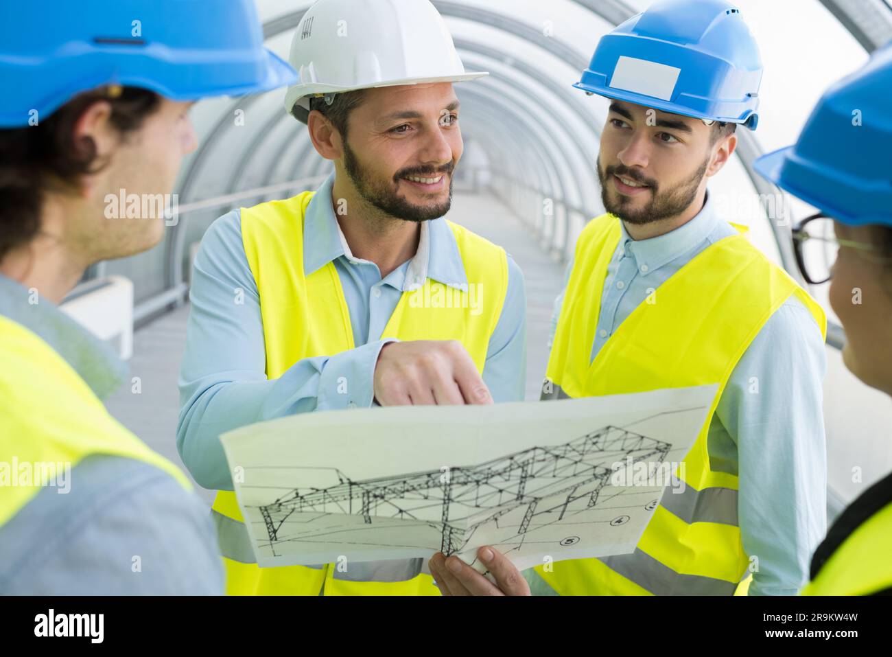 engineer looking over building plans with construction workers Stock ...