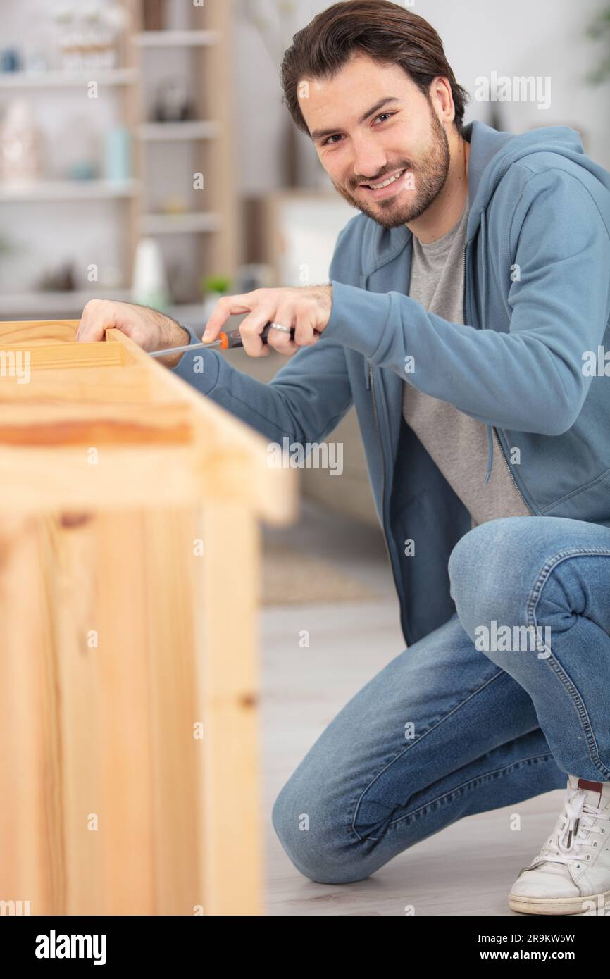 man putting together self assembly furniture Stock Photo - Alamy