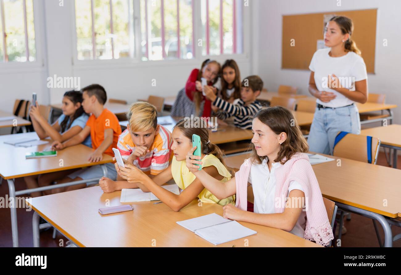 Schoolchildren use mobile phones at the lesson in classroom Stock Photo ...