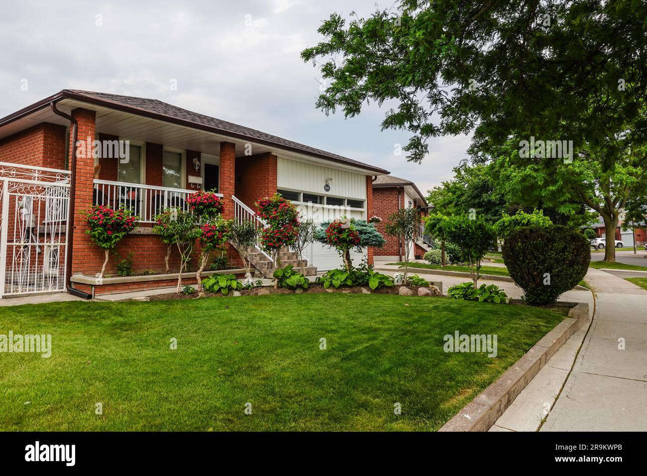 A bungalow or a one story high house with a well maintained front lawn ...