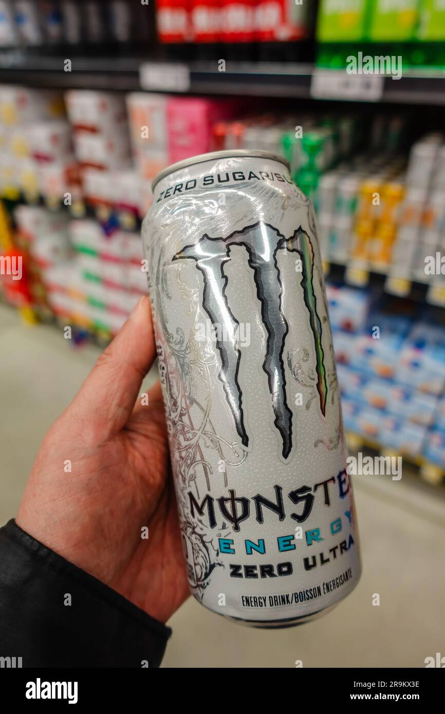 Hand holding a can of monster energy drink in the grocery store Stock ...
