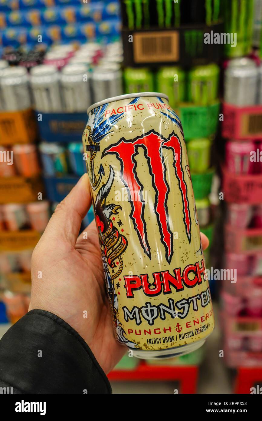 Hand holding a can of monster energy drink in the grocery store Stock ...