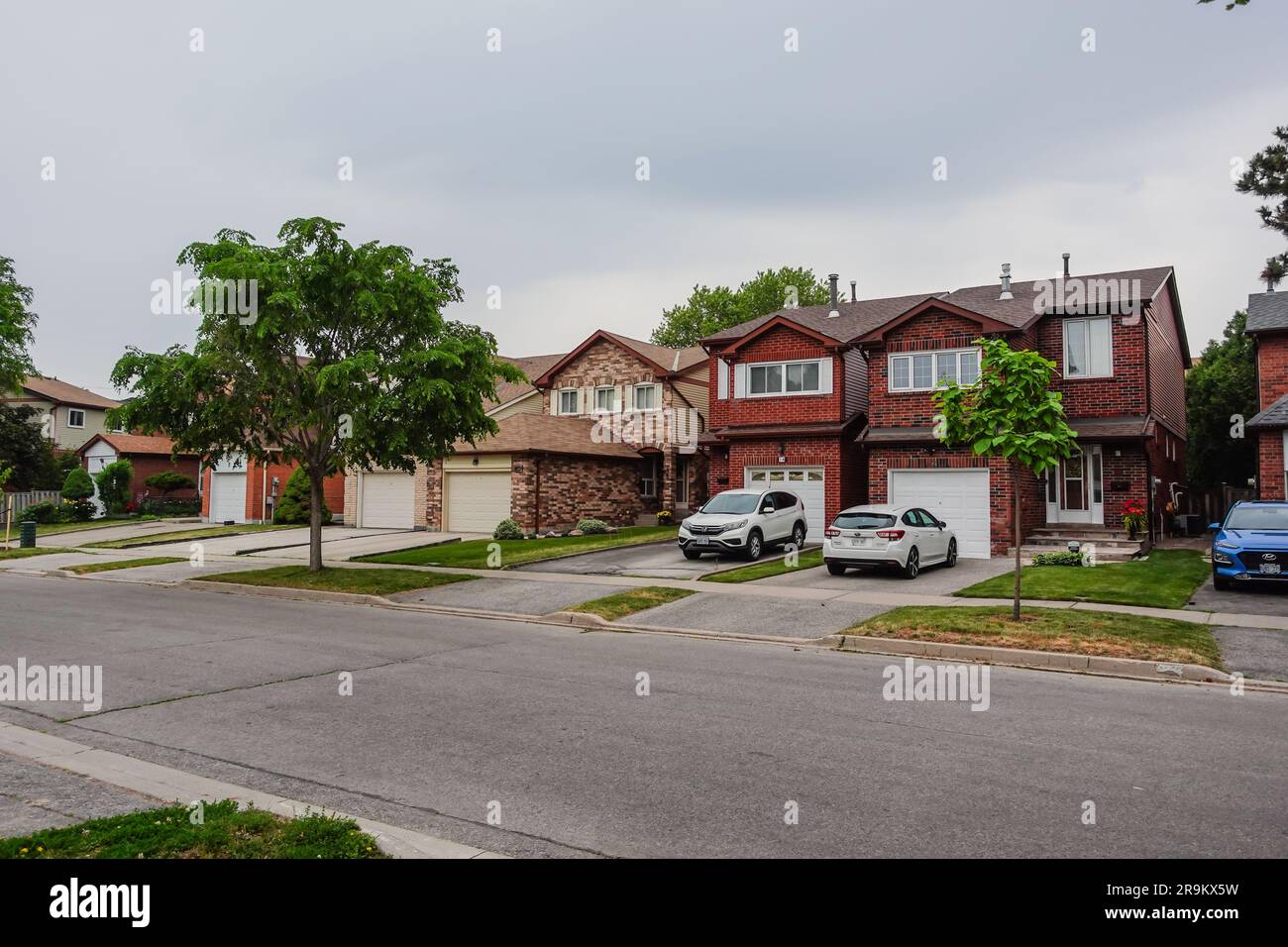 Suburban residential street with brick houses, a typical neighbourhood ...