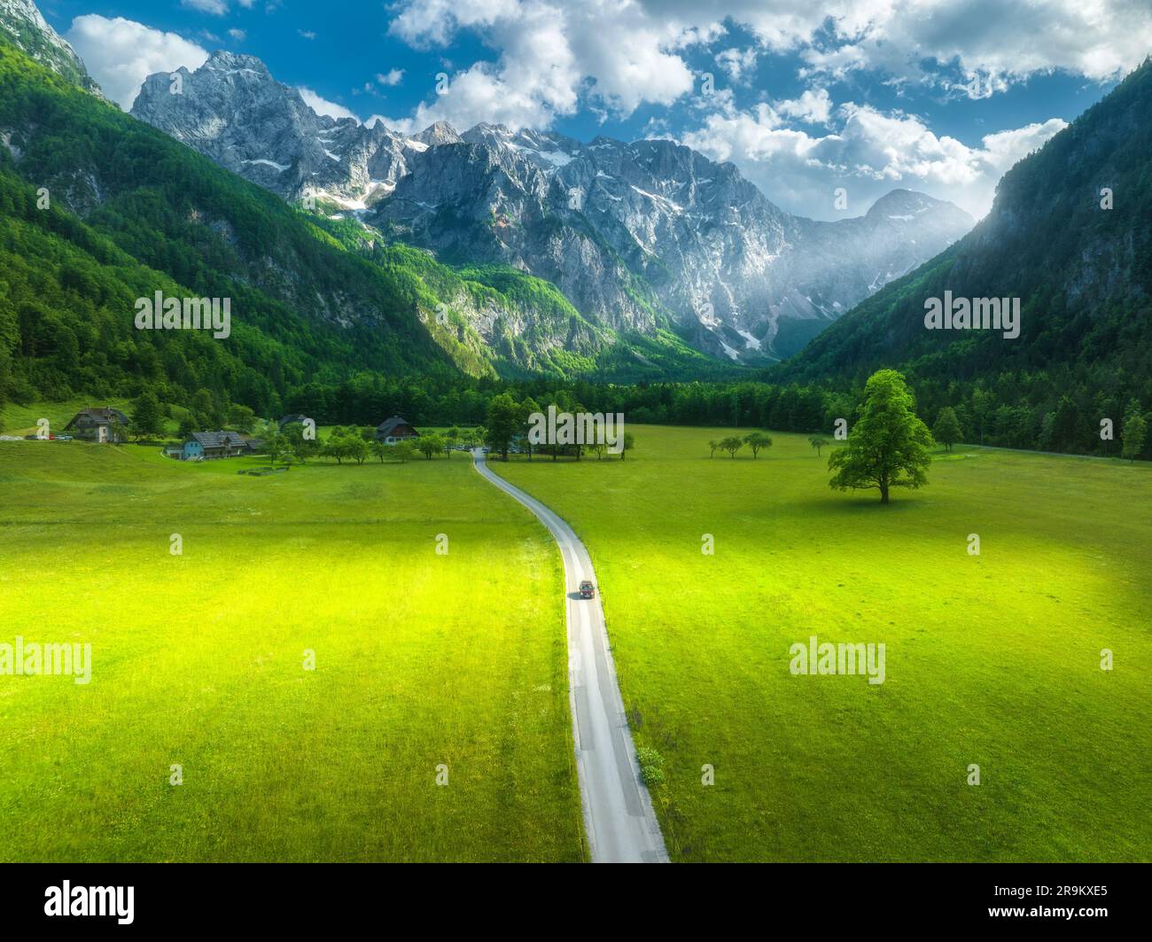 Aerial view of road in alpine mountains, green meadows, trees Stock ...