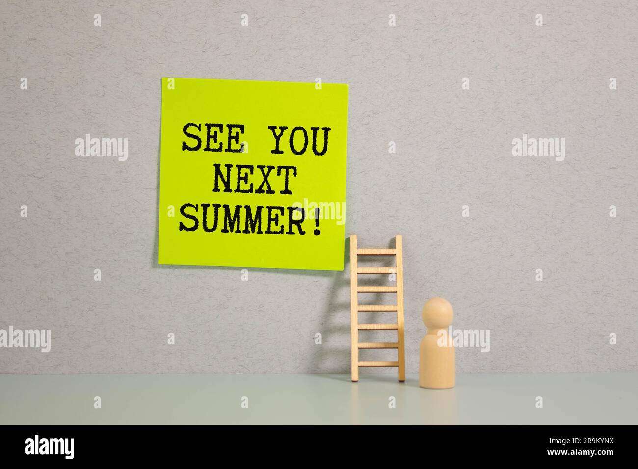 See you next Summer written on a note at the office table with empty ...