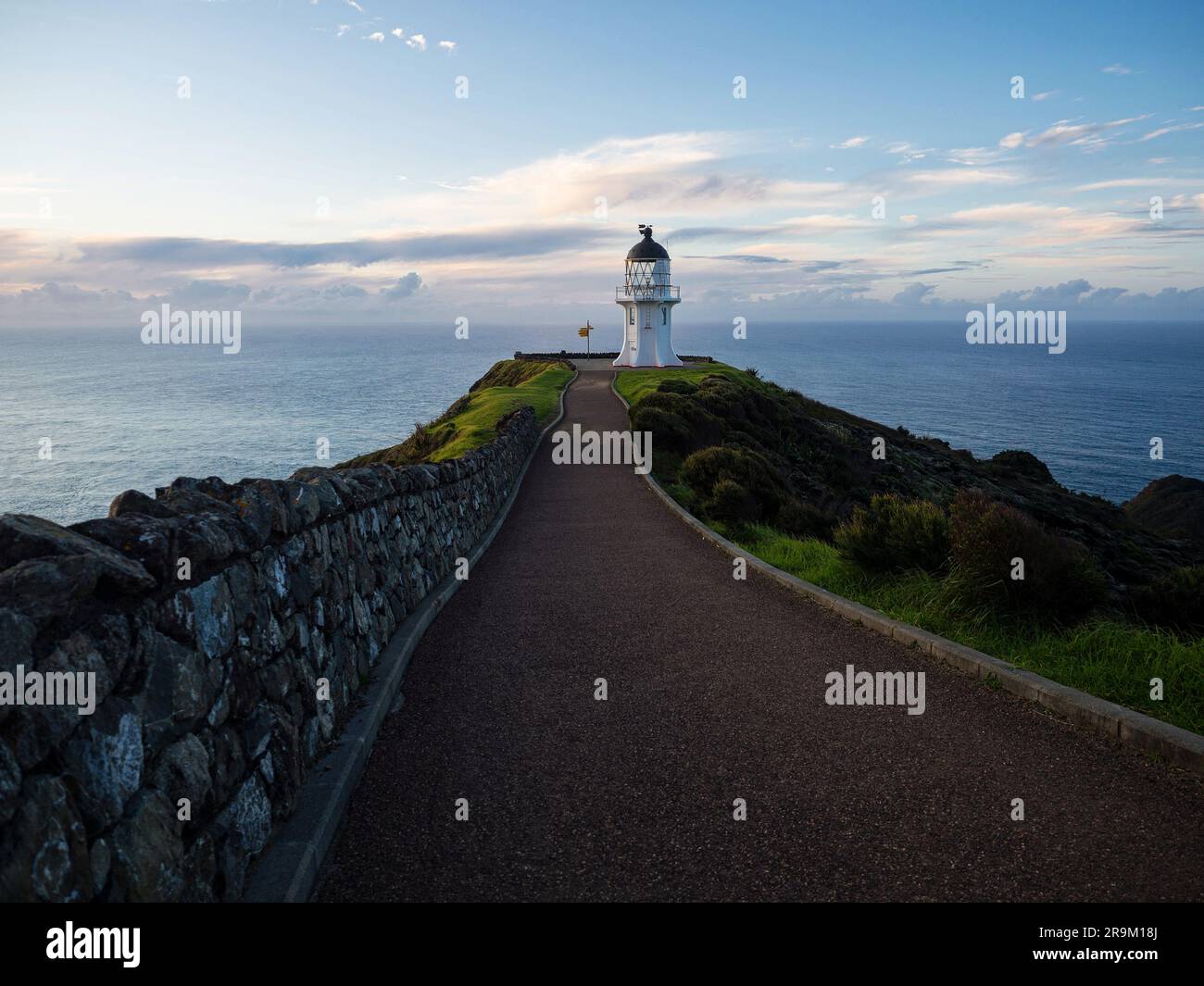 Pedestrian asphalt road walkway leading to historic white lighthouse ...