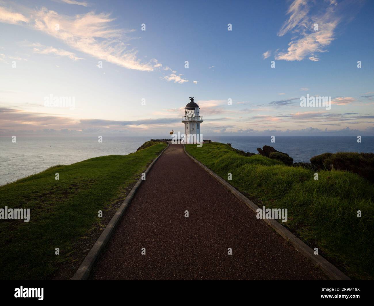 Pedestrian asphalt road walkway leading to historic white lighthouse ...