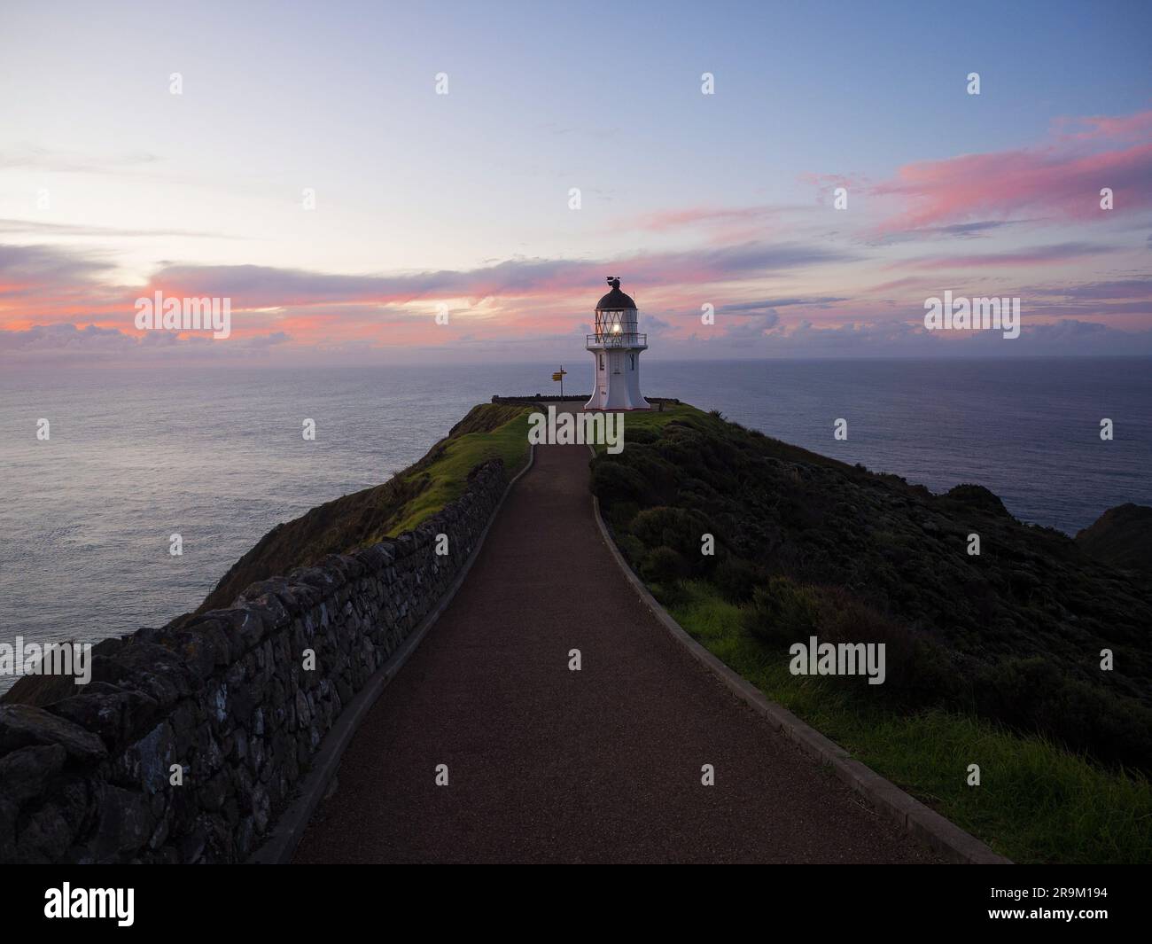 Pedestrian asphalt road walkway leading to historic white lighthouse ...
