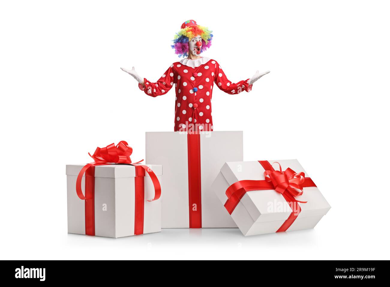 Clown in a present box making a surprise isolated on white background ...