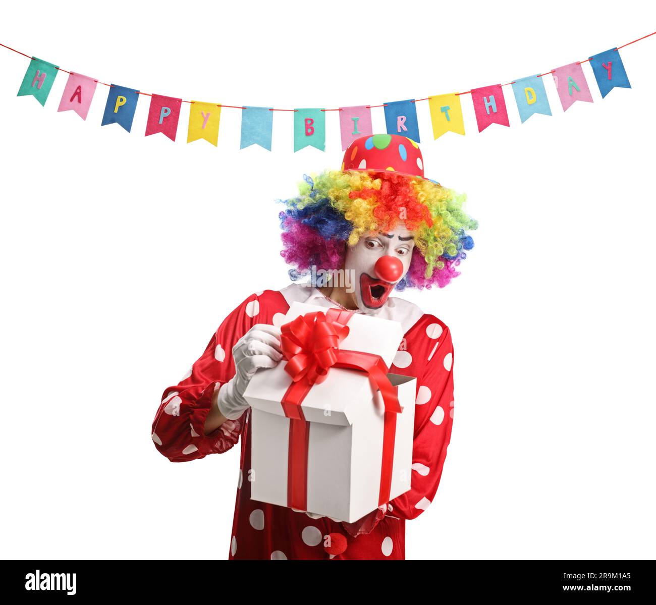 Clown opening a present box at a birthday party isolated on white ...
