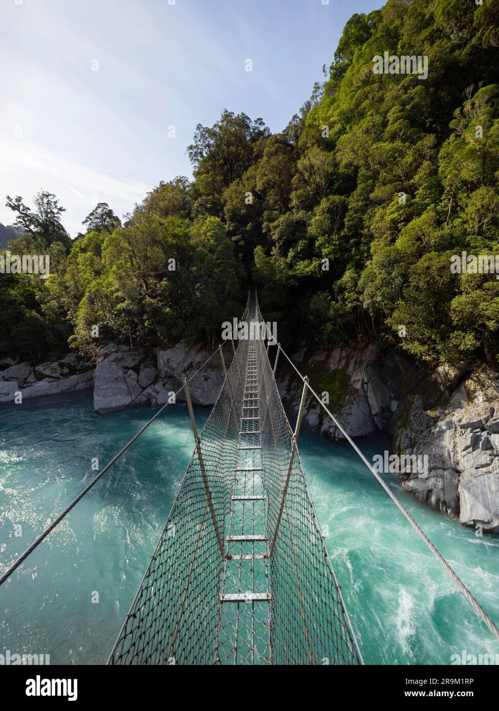 Cesspool Gorge hanging metal swing bridge leading over turquoise ...