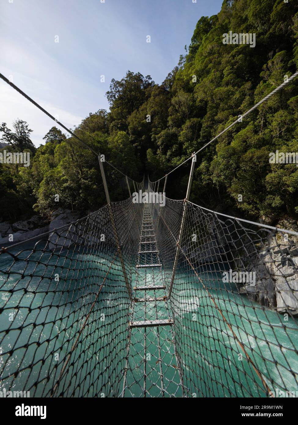 Cesspool Gorge hanging metal swing bridge leading over turquoise ...