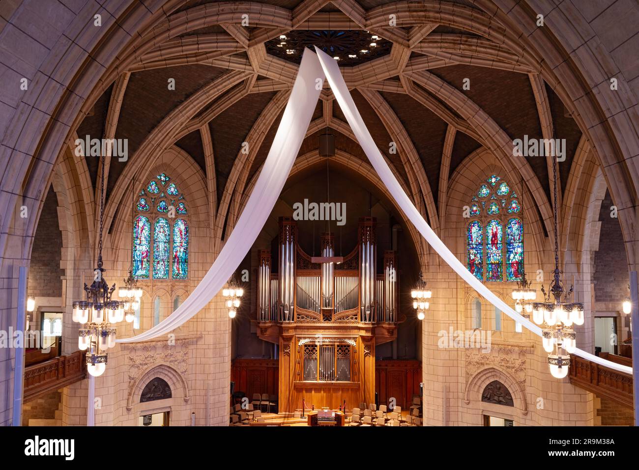sanctuary and stained glass windows under rib vaulted ceiling of ...