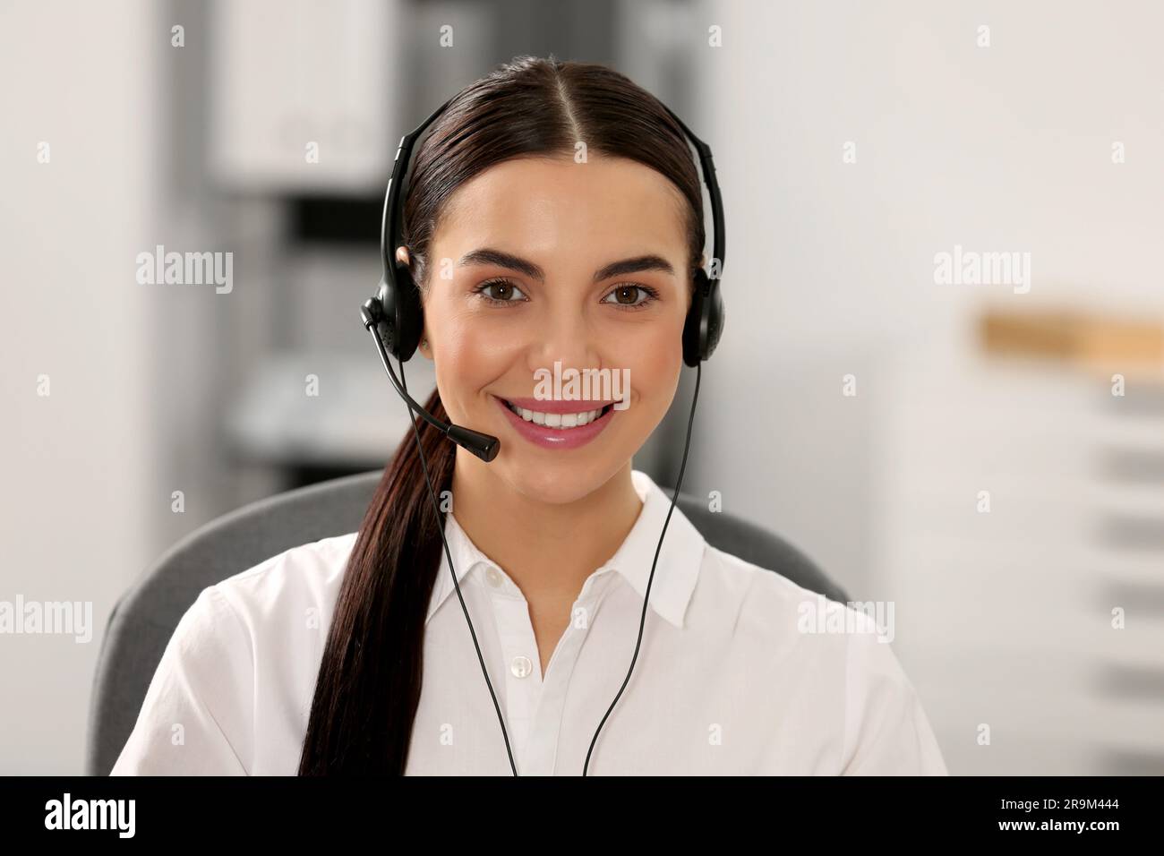 Hotline operator with headset working in office Stock Photo - Alamy
