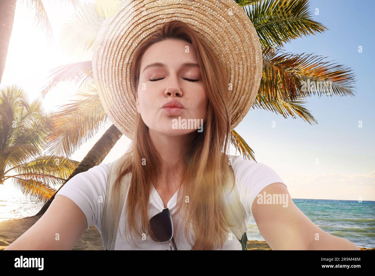 Beautiful woman in straw hat taking selfie at resort Stock Photo - Alamy