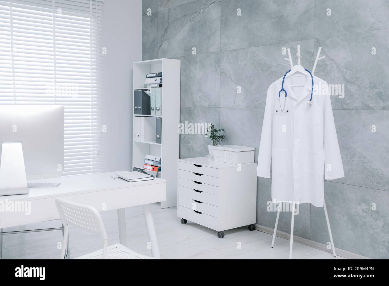 White doctor's gown and stethoscope hanging on rack in clinic Stock ...