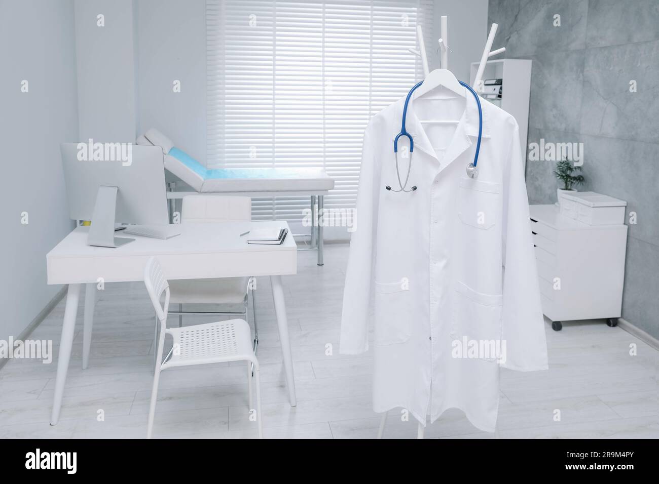White doctor's gown and stethoscope hanging on rack in clinic Stock ...