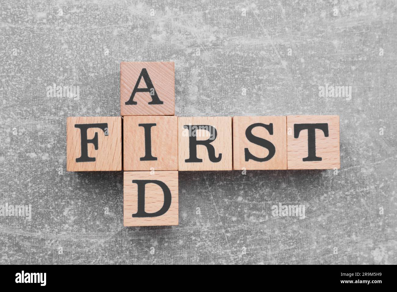 Words First Aid made of wooden cubes on light grey table, top view ...