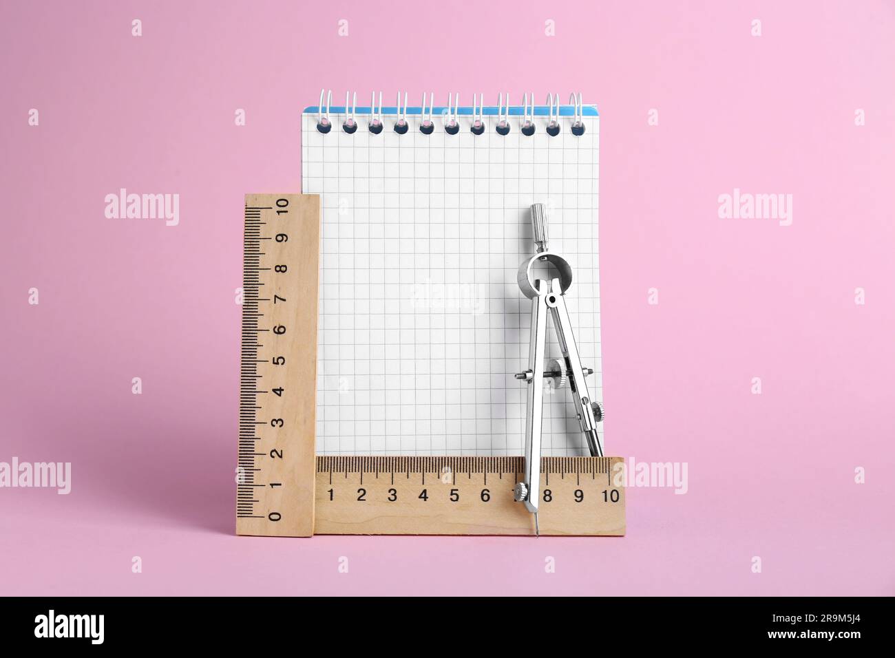 Rulers, notebook and compass on pink background Stock Photo - Alamy