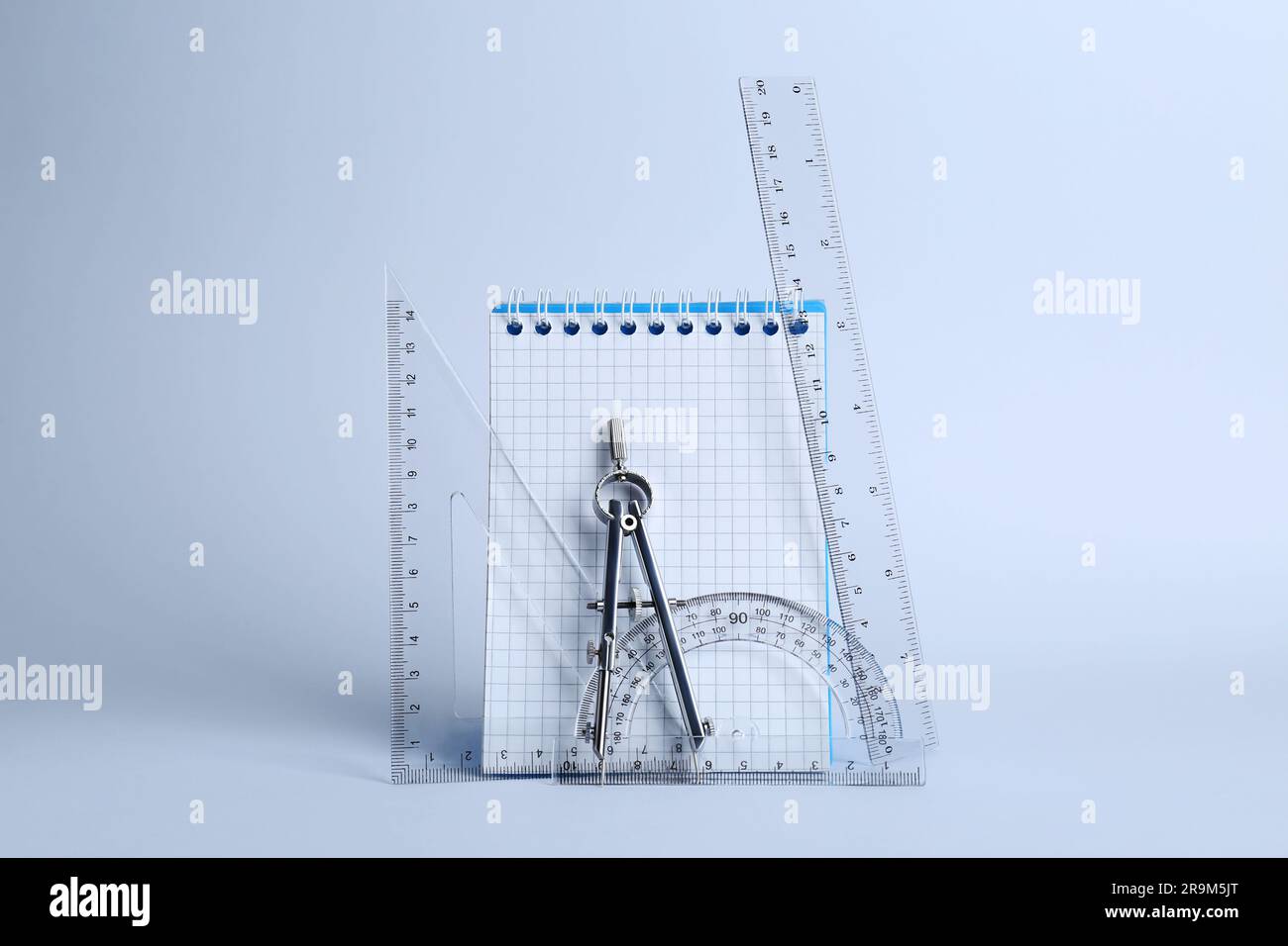 Triangle, notebook, protractor and compass on white background Stock ...