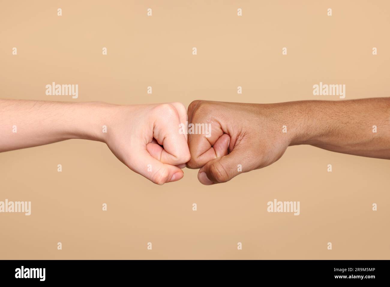 International relationships. People making fist bump on light brown ...