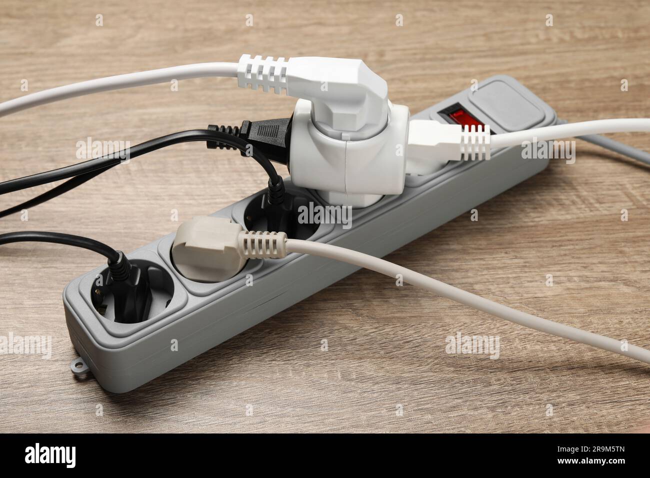 Power strip with extension cord on wooden floor. Electrician's ...