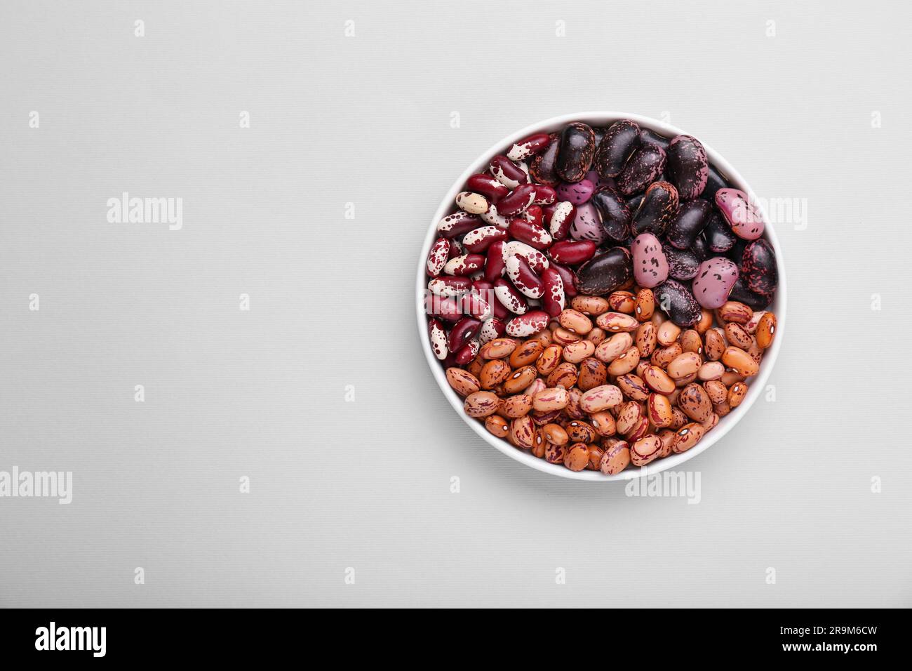 Different kinds of kidney beans in bowl on white background, top view ...
