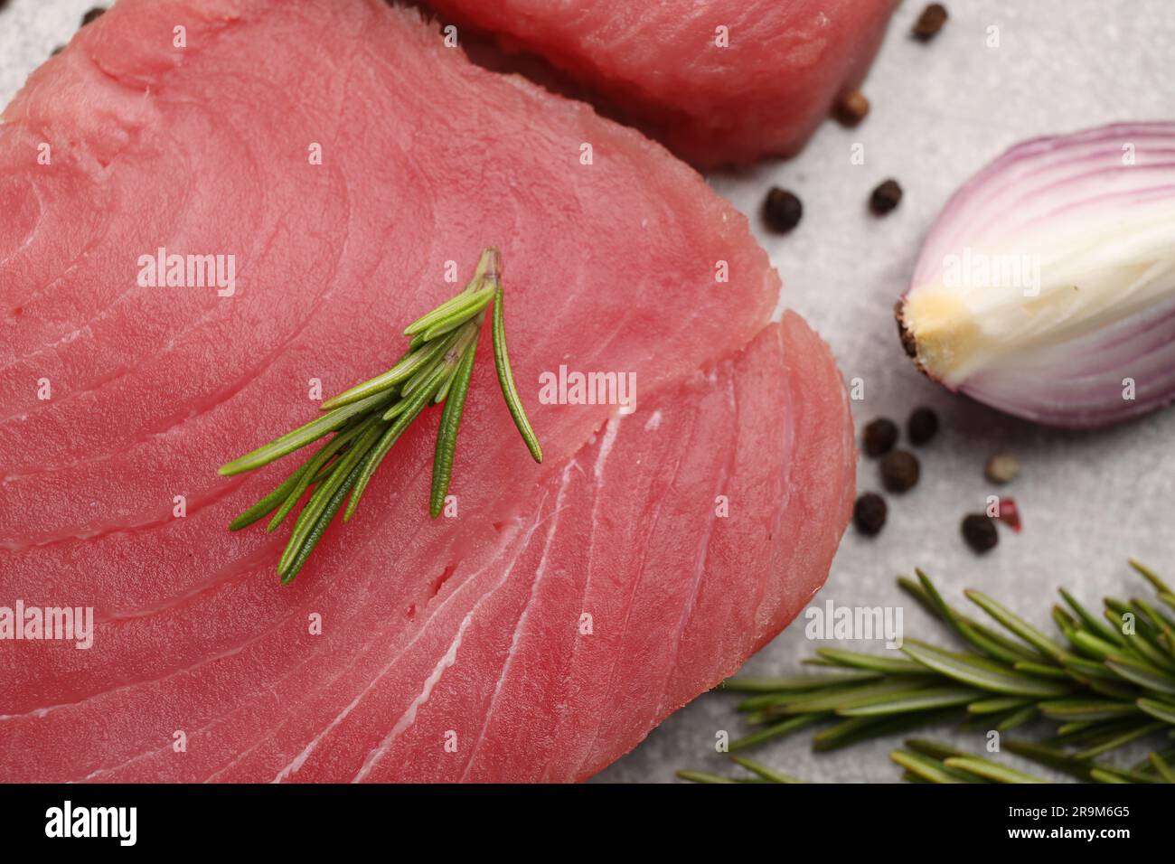 Fresh raw tuna fillet with rosemary on light gray table, top view Stock ...