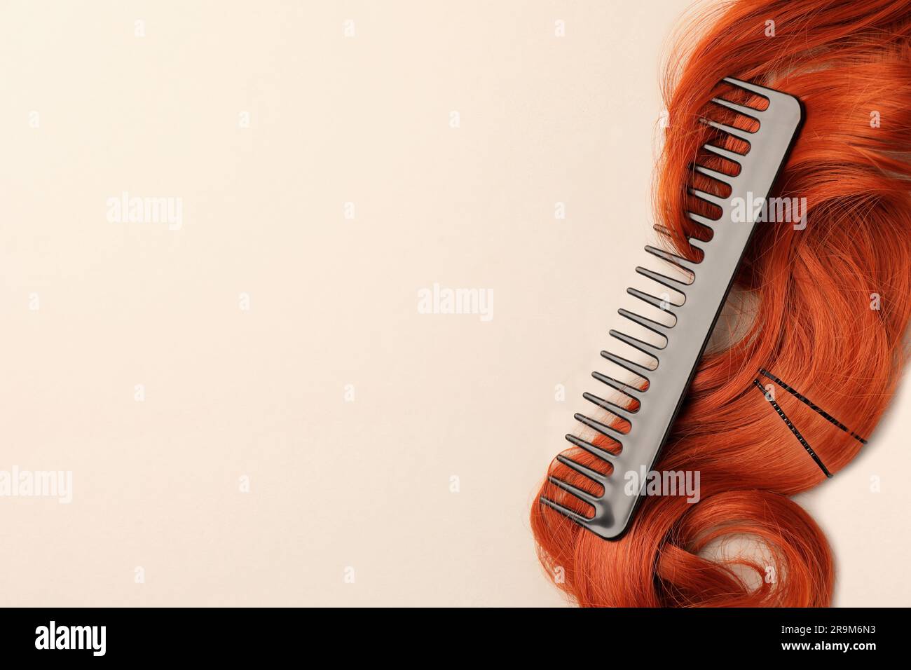 Comb with red hair strand on light background, top view. Space for text ...