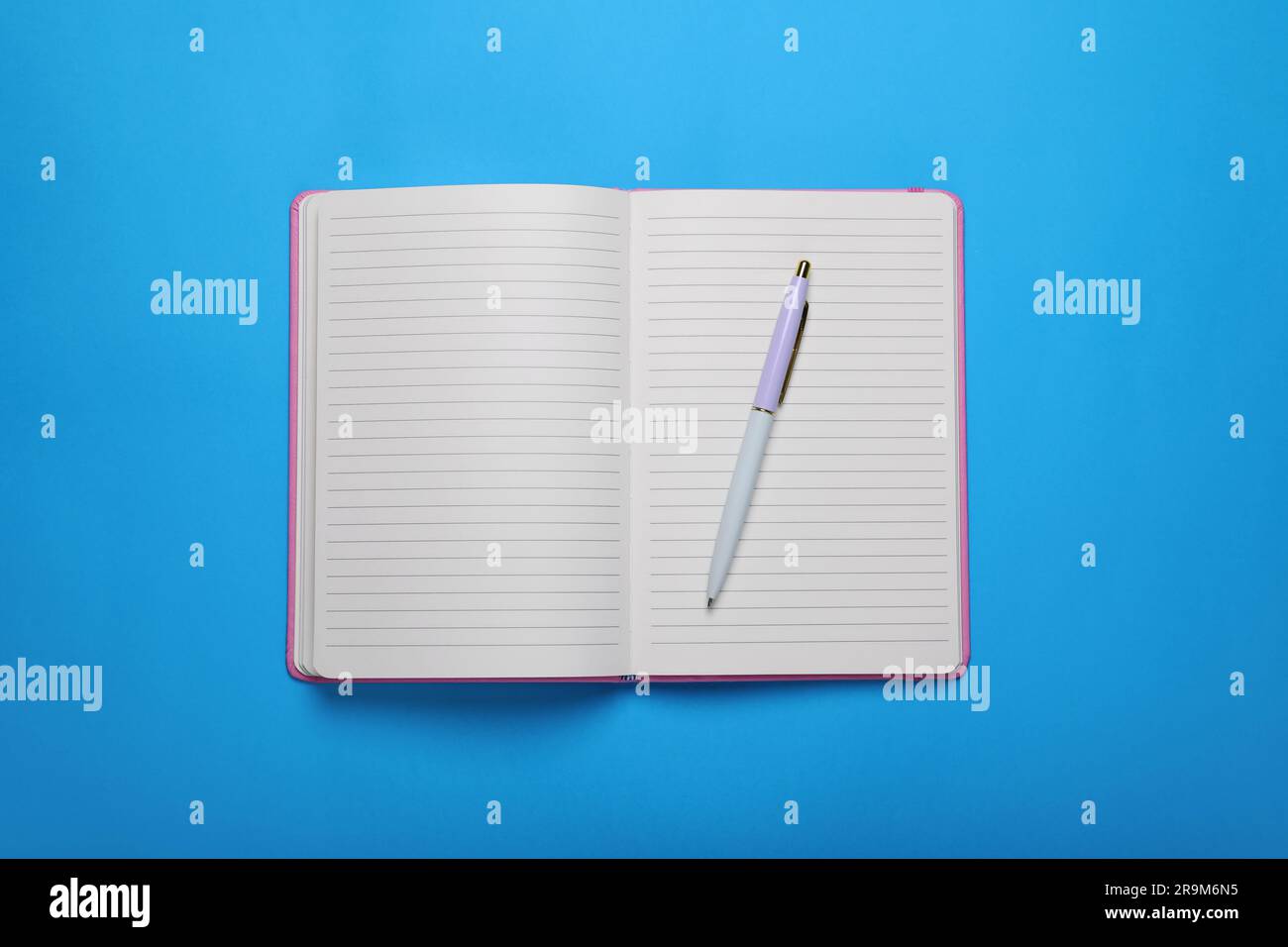Open notebook and pen on light blue background, top view Stock Photo ...