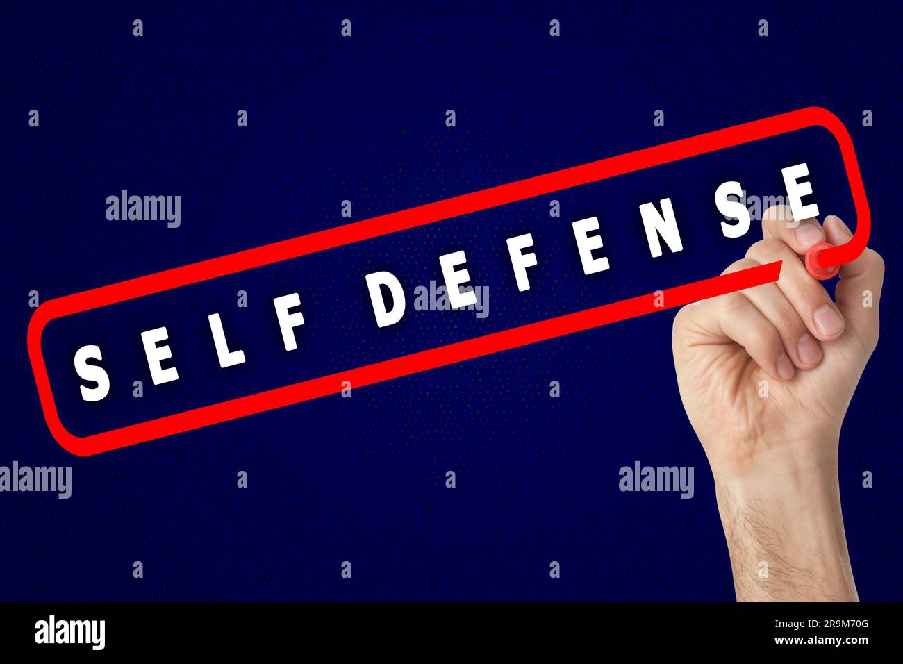 Man contouring words Self Defense with marker glass board against blue ...